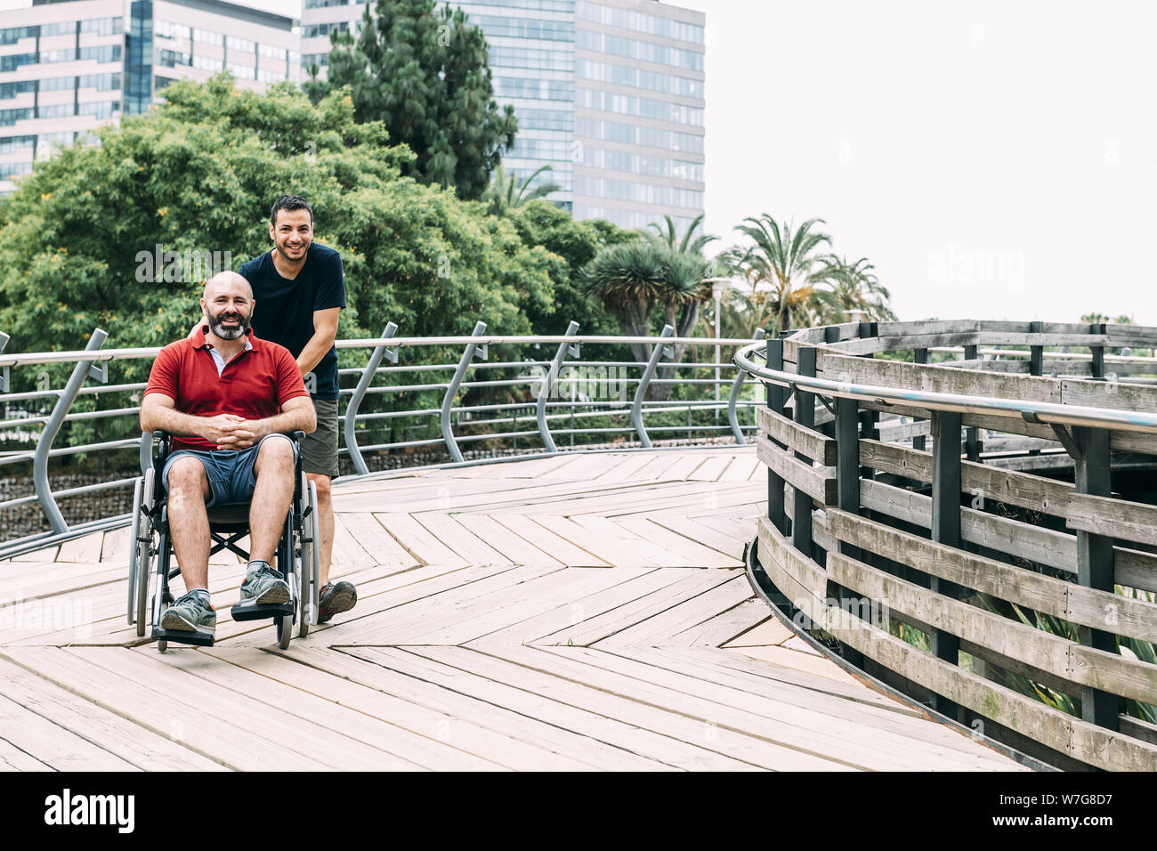 Helping friend in wheelchair hi-res stock photography and images - Alamy