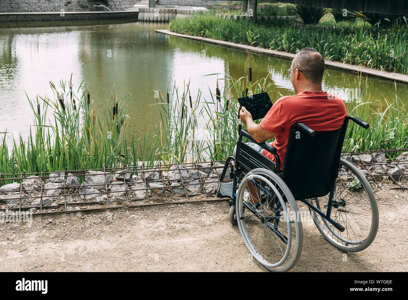 disabled man in wheelchair having fun while resting using a tablet ...