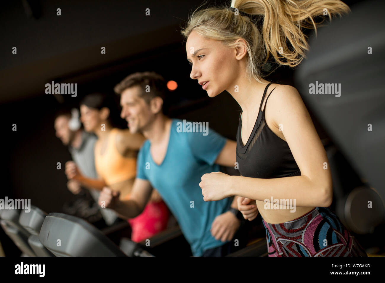 Group of young people using threadmill in modern gym Stock Photo - Alamy