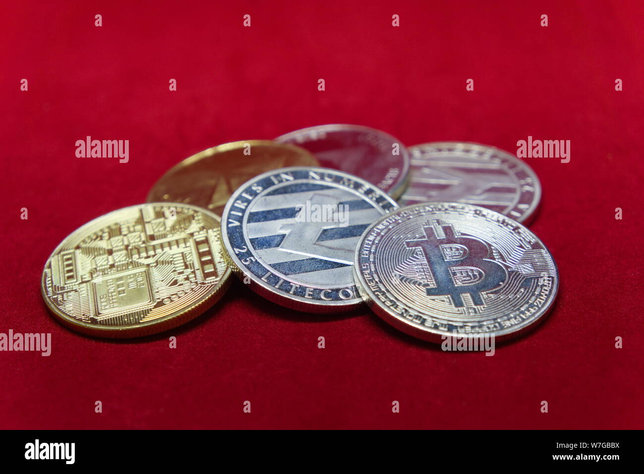 close up of silver and gold cryptocurrency with a red velvet background ...