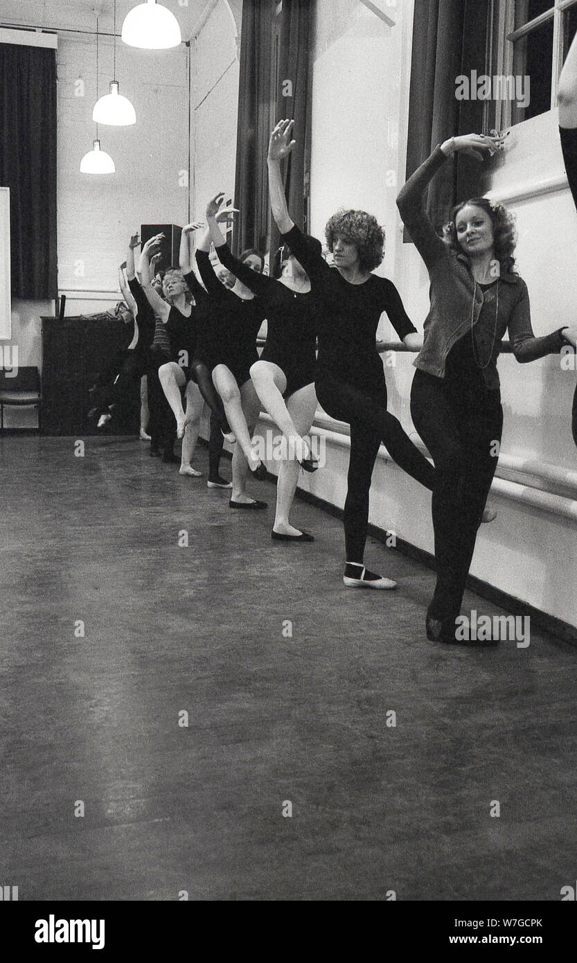 1970s, historical, adult ballet class, women holding onto a bar at the ...