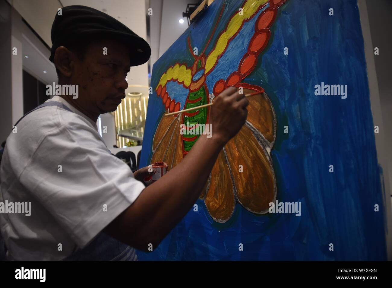 Jakarta, Indonesia. 6th Aug, 2019. An artist works on a painting in ...