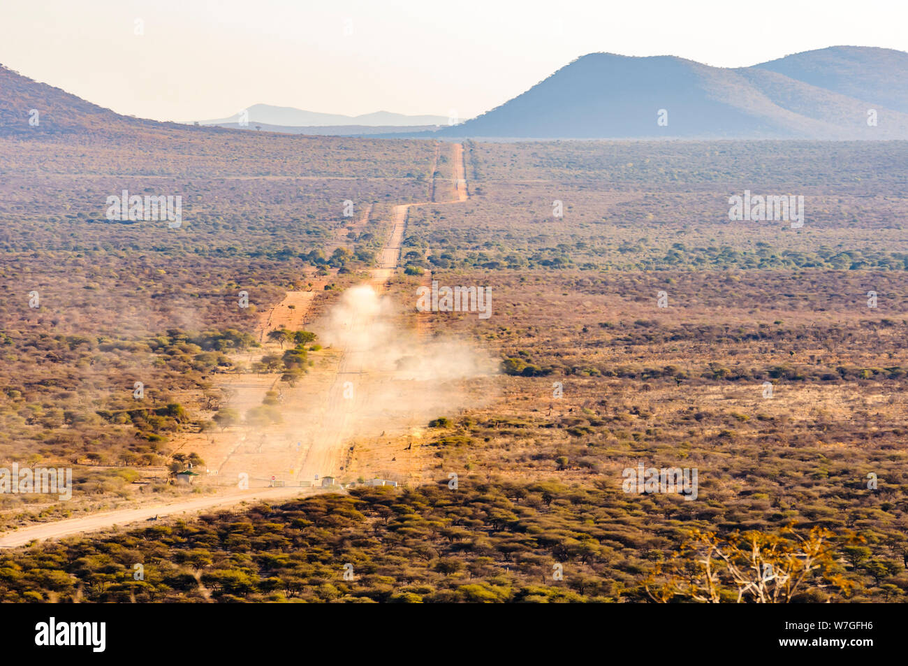 Pick-up truck creates a dust cloud as it dives through the Kalahari ...