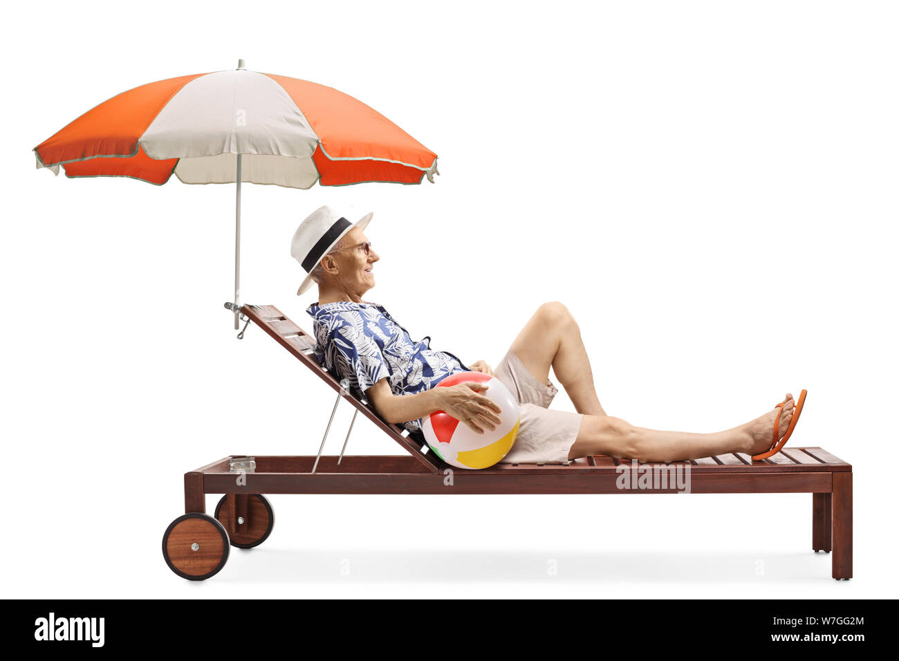 Full length shot of an elderly man enjoying on a sunbed under umbrella ...