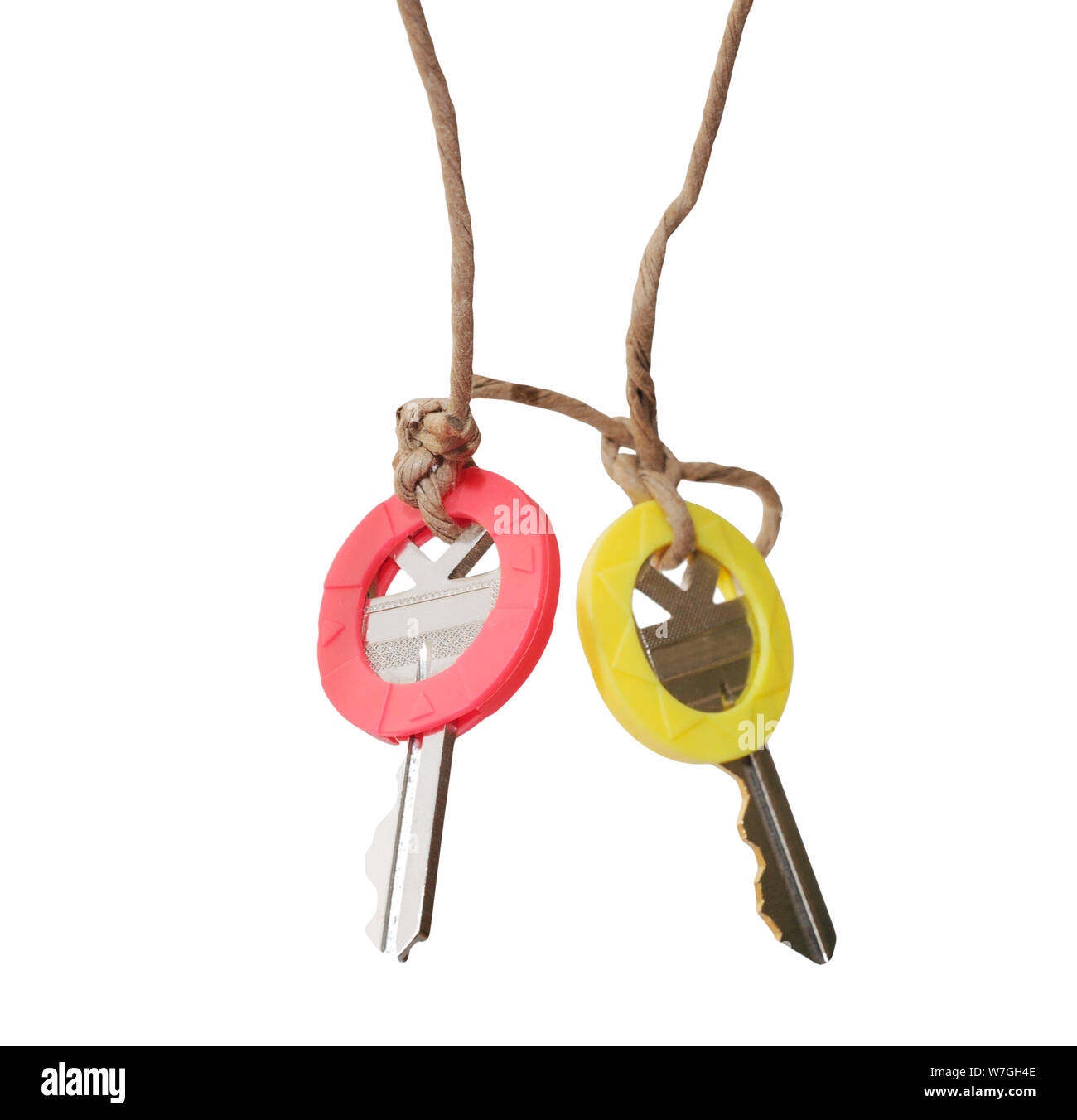 yellow and red keys with caps that are tied together isolated on white ...
