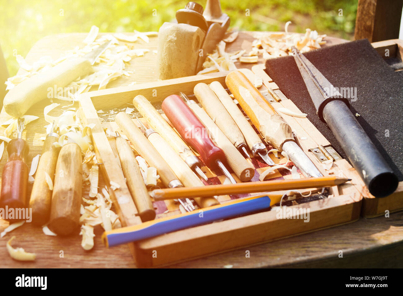 Different tools for wood carving in wooden box with wood shavings ...