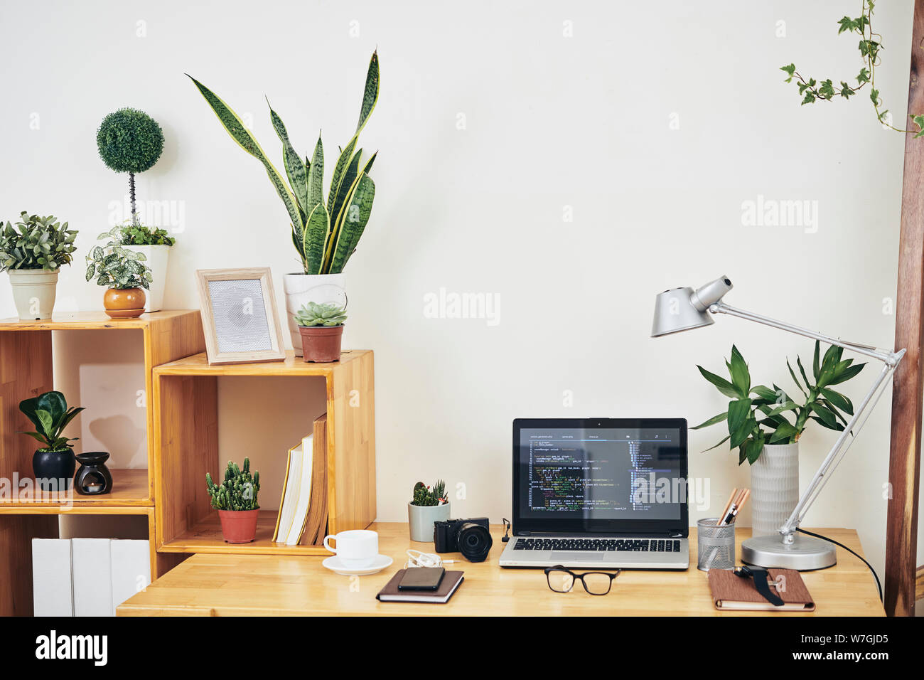 Wooden table of freelance programmer with opened laptop, planner ...