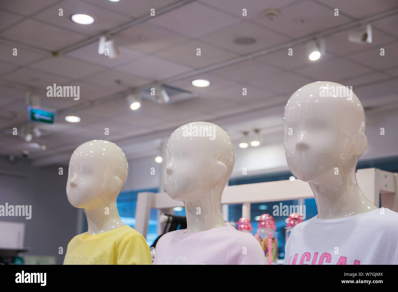 children mannequins with modern clothes in fashion store display window ...