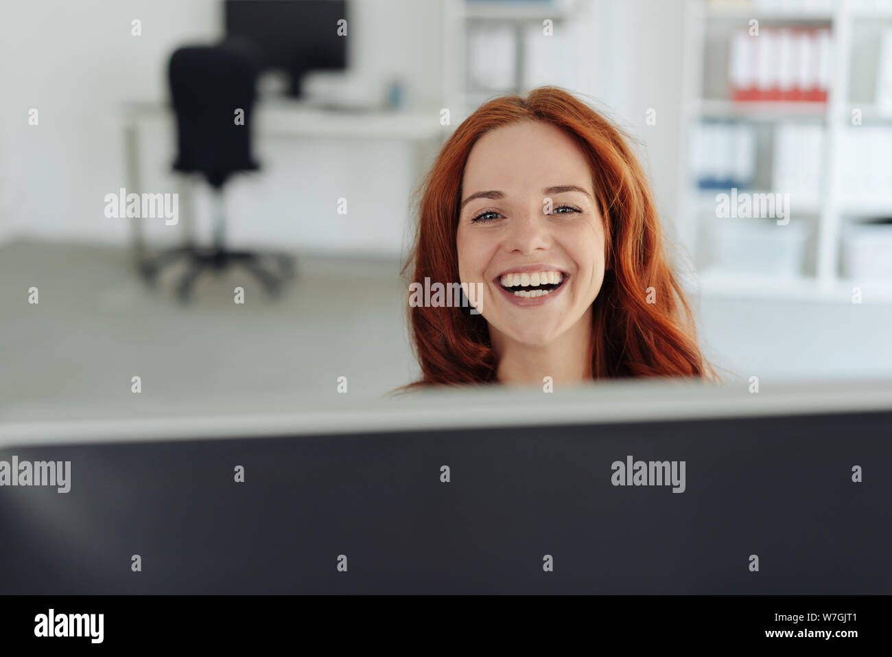 Woman peering over computer hi-res stock photography and images - Alamy