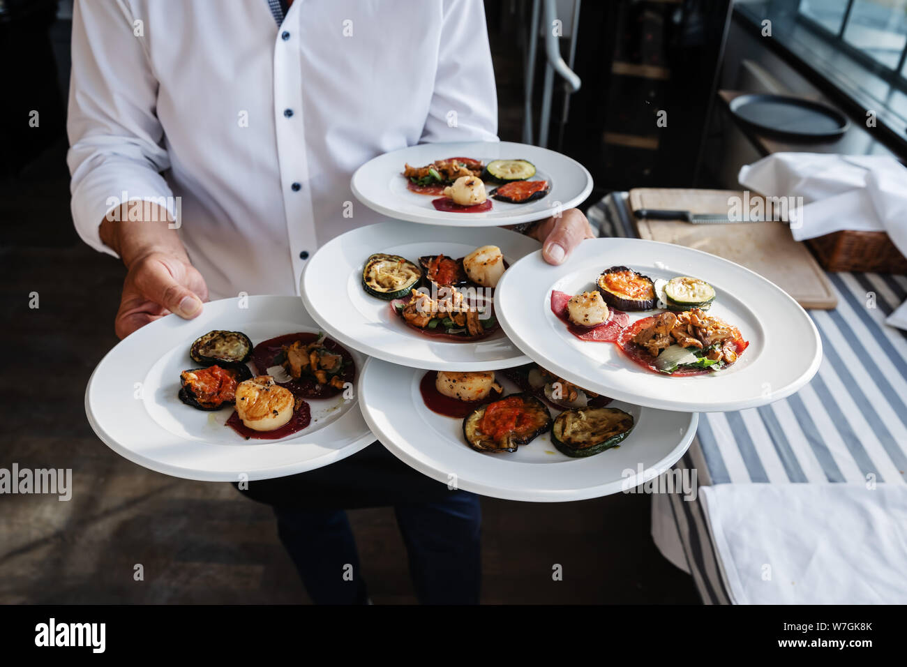picture of a waiter who serves Italian antipasti in an outdoor ...