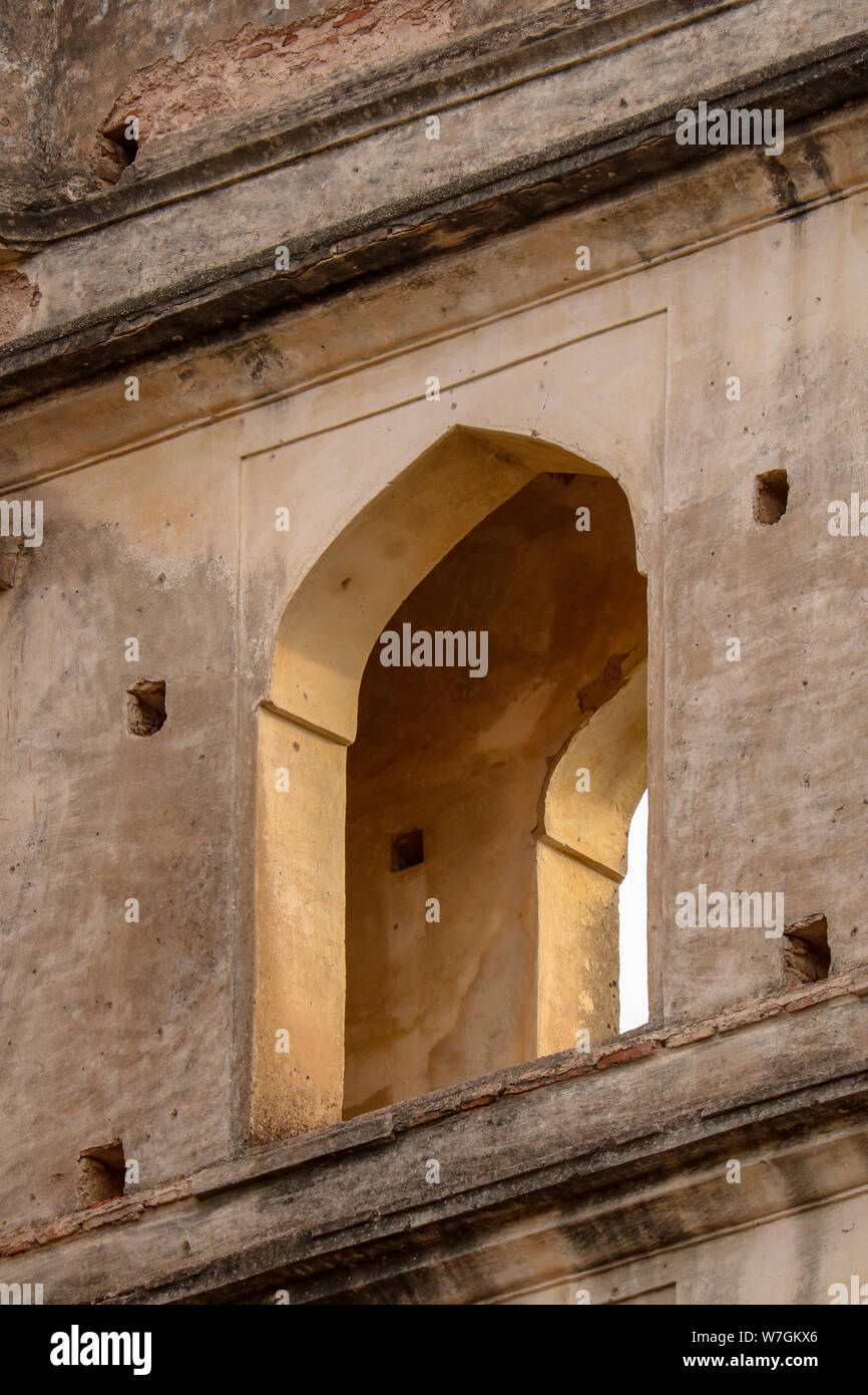 The evening sun shines at sunset through a window of the Orchha Palace ...