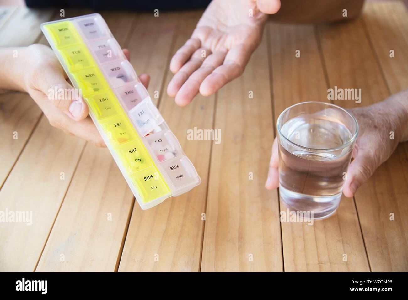 Doctor is assist patient to eat medicine tablet in pillbox correctly ...
