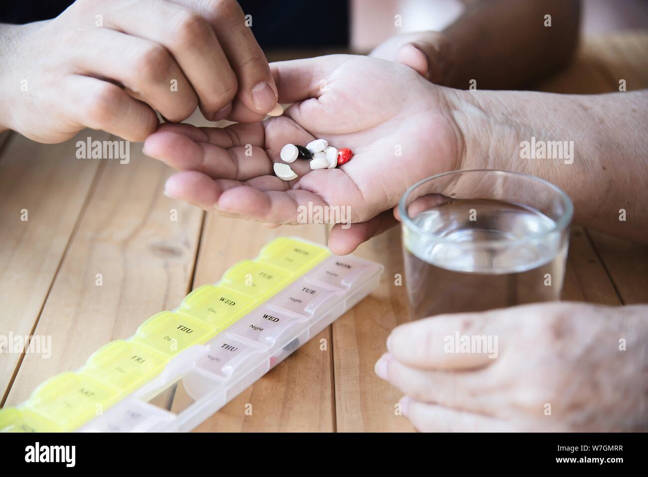 Doctor is assist patient to eat medicine tablet in pillbox correctly ...