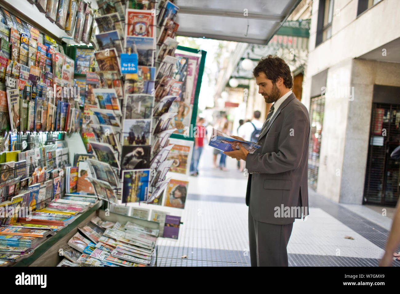 Man reading at a magazine stand Stock Photo - Alamy