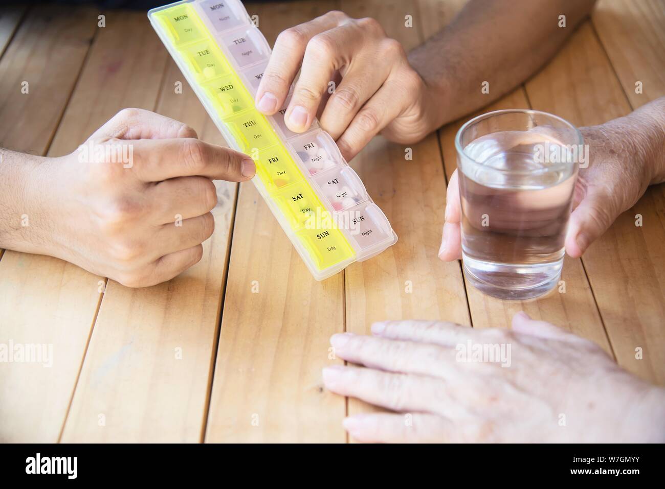 Doctor is assist patient to eat medicine tablet in pillbox correctly ...