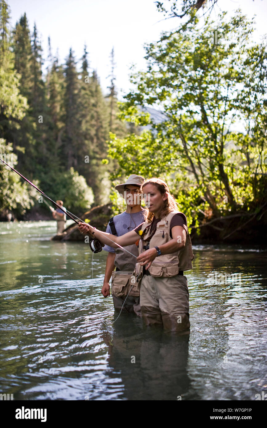 Instructor teaching young man to fish Stock Photo - Alamy