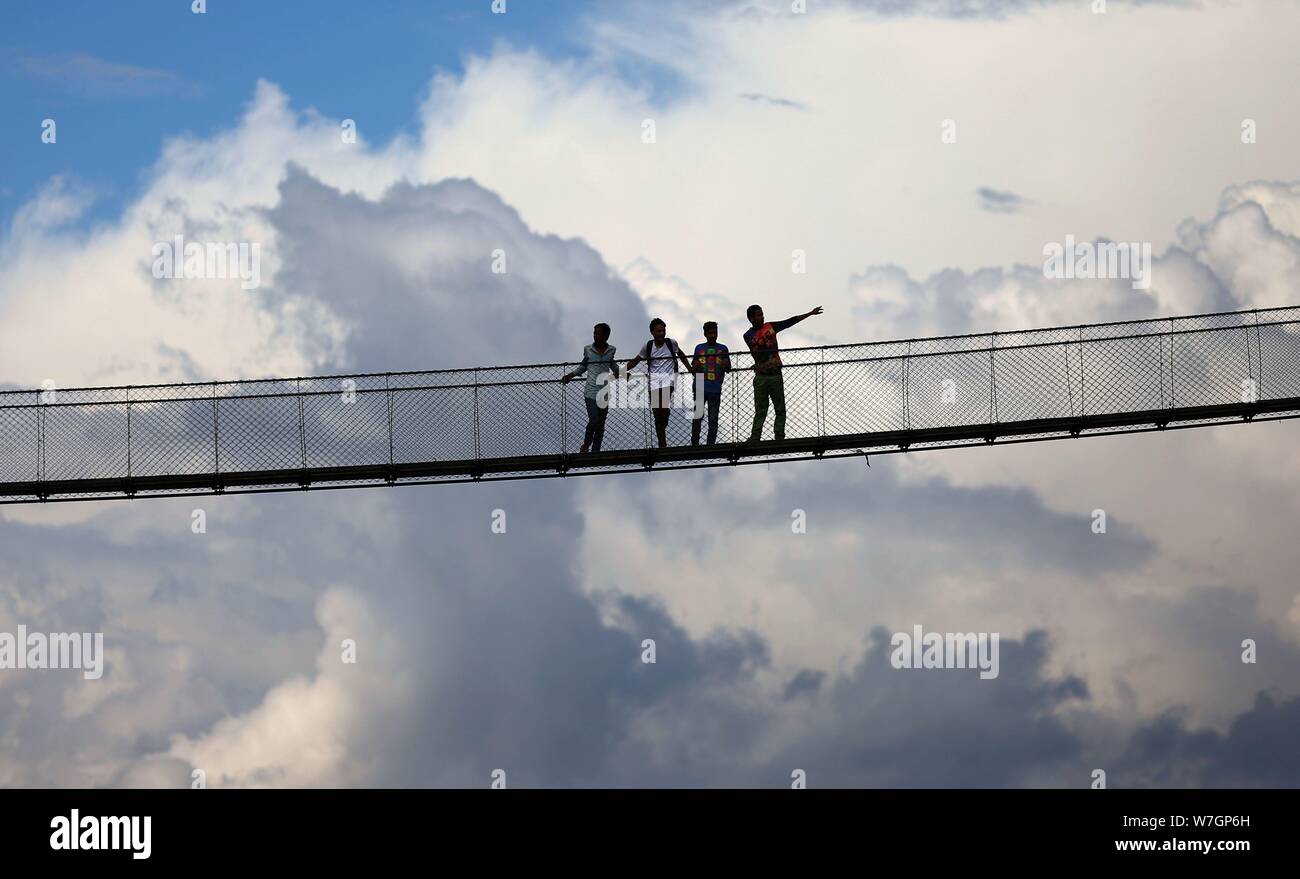Kathmandu, Nepal. 6th Aug, 2019. People walk through the suspension ...
