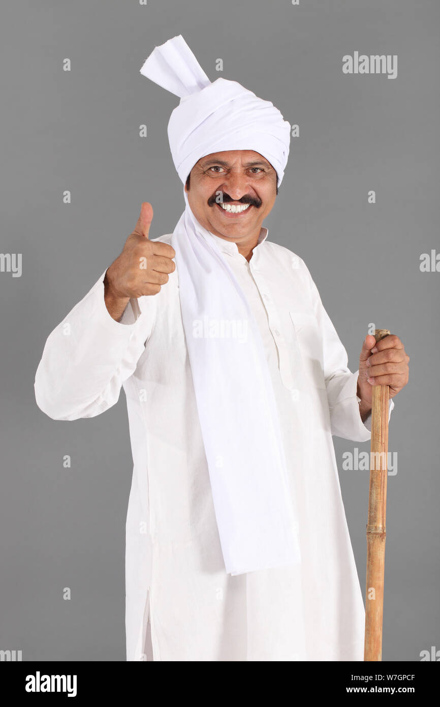 Rural man standing with his cane and showing thumbs up sign Stock Photo ...