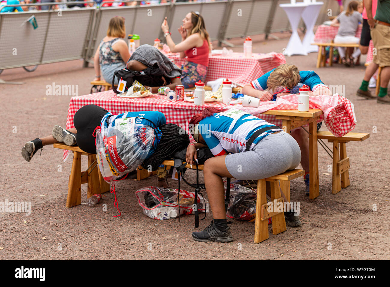 Shattered female cyclists sleeping in awkward positions on benches ...