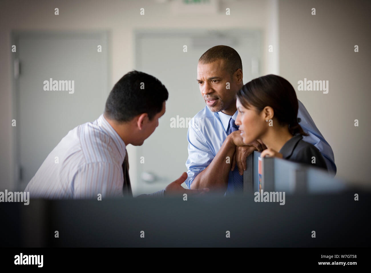 Mid-adult businessman having a serious discussion with two of his ...