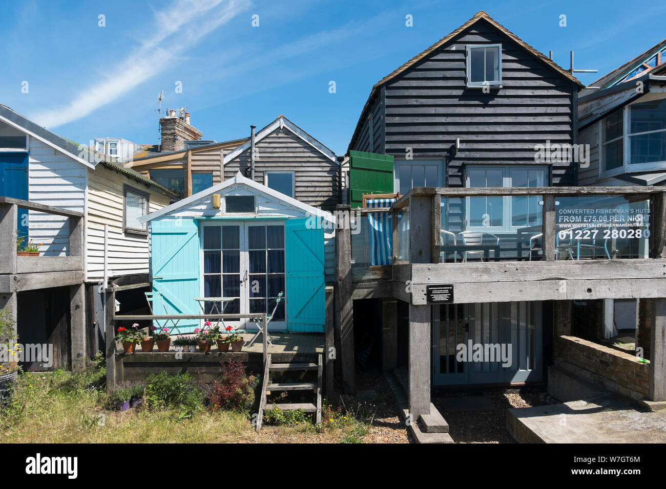 Traditional weatherboard houses and huts along the beach at Whitstable ...