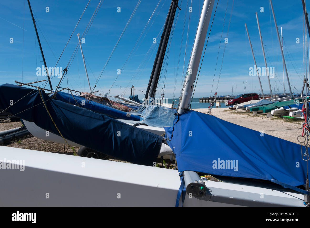 Sailing boats and catamarans on the beach along the seafront boardwalk ...