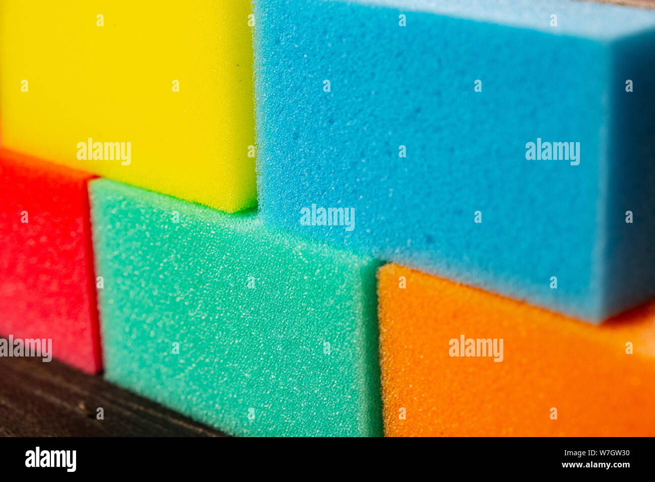Sponges of different colors in dark background forming a wall. Pieces ...