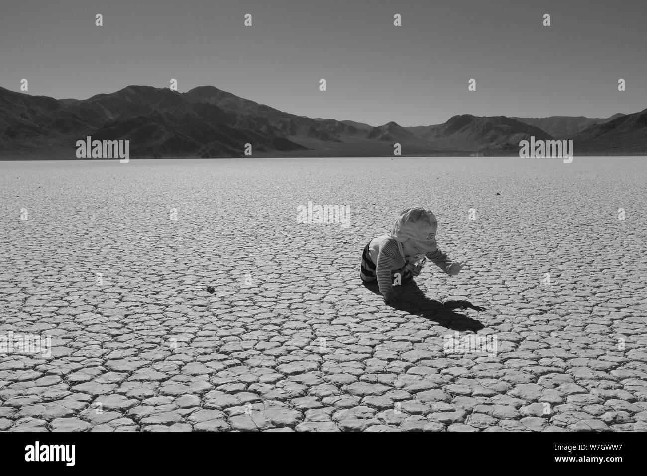 Baby alone on a dry lakebed Stock Photo - Alamy