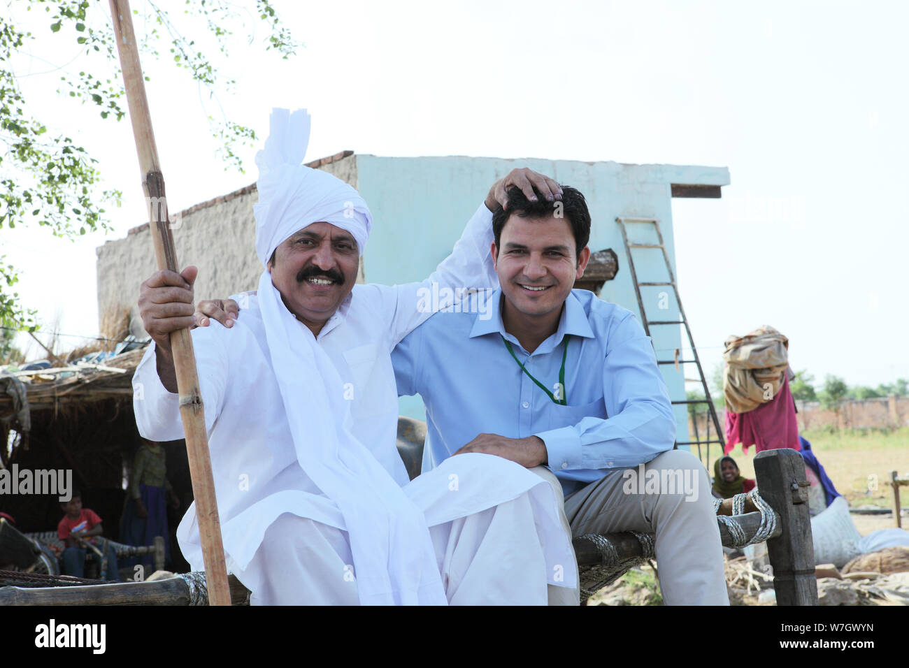 Rural man with his son sitting on cot and smiling Stock Photo - Alamy