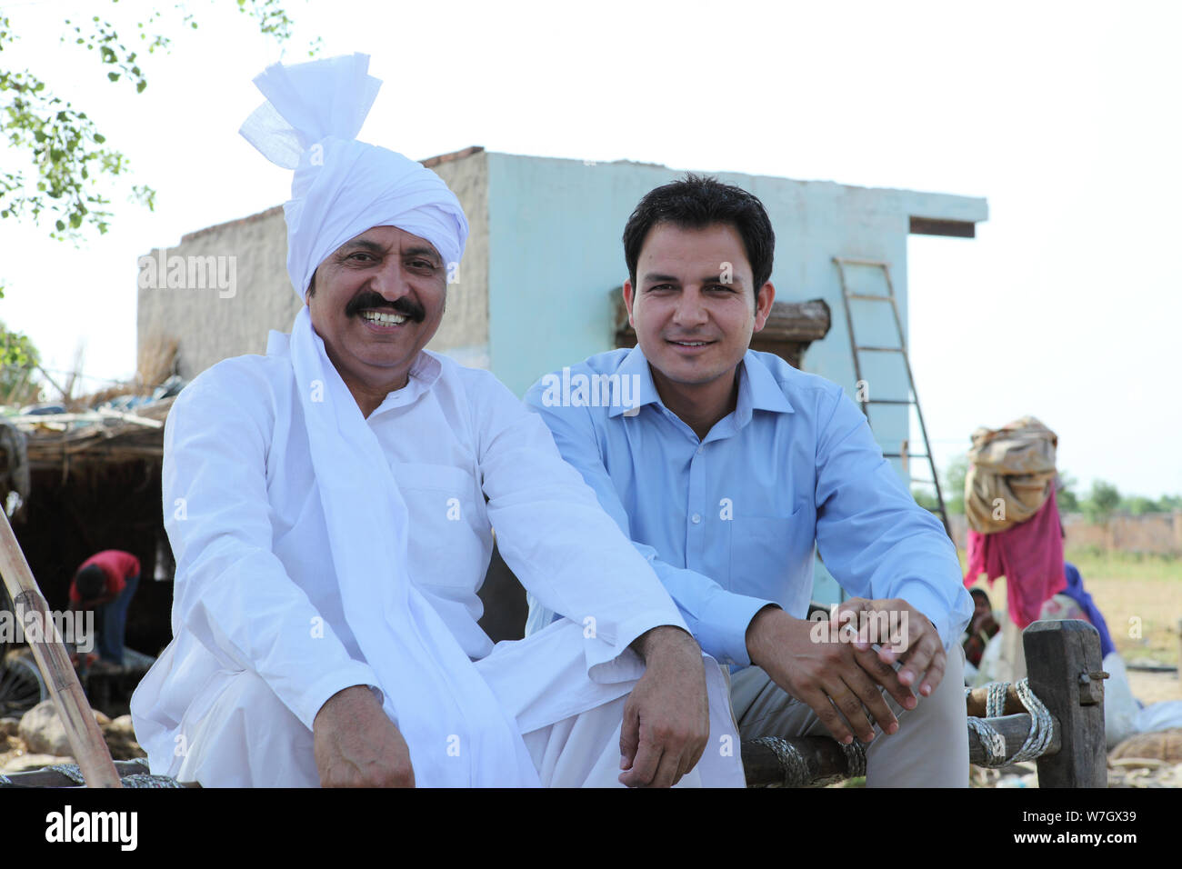 Rural man with his son sitting on cot Stock Photo - Alamy