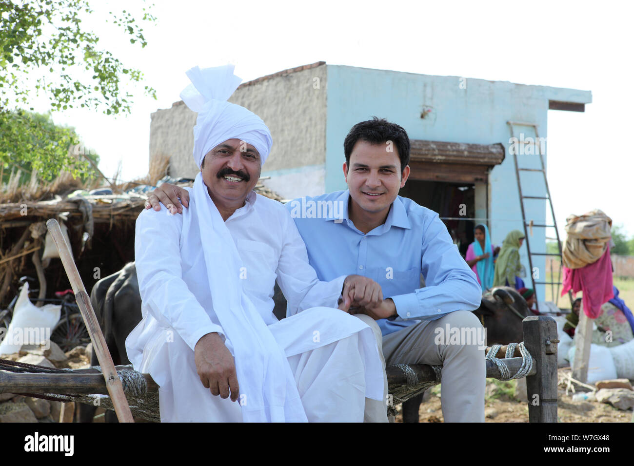 Rural man with his son sitting on cot Stock Photo - Alamy