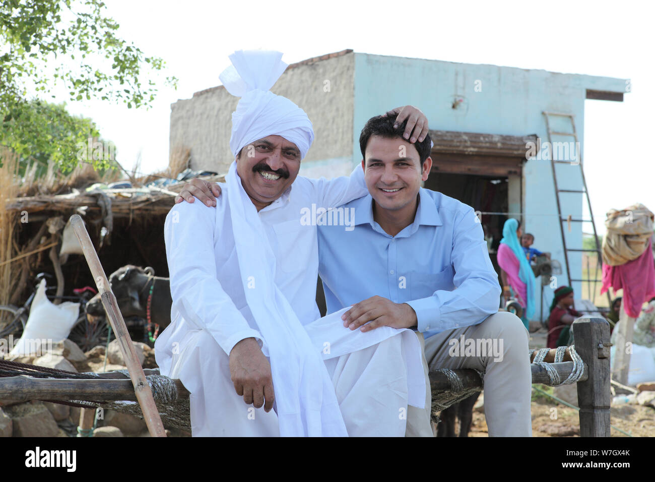 Rural man with his son sitting on cot and smiling Stock Photo - Alamy