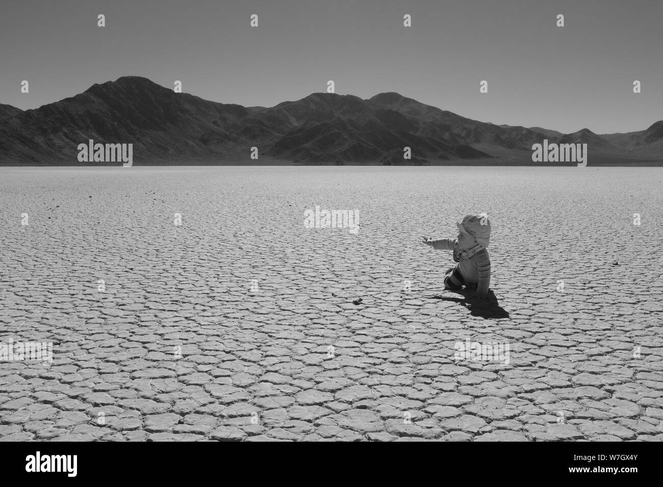 Baby alone on a dry lakebed Stock Photo - Alamy