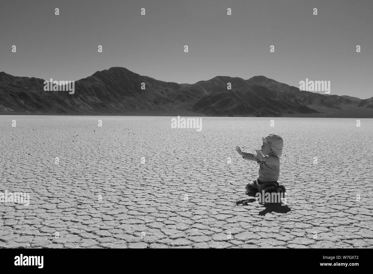 Baby alone on a dry lakebed Stock Photo - Alamy