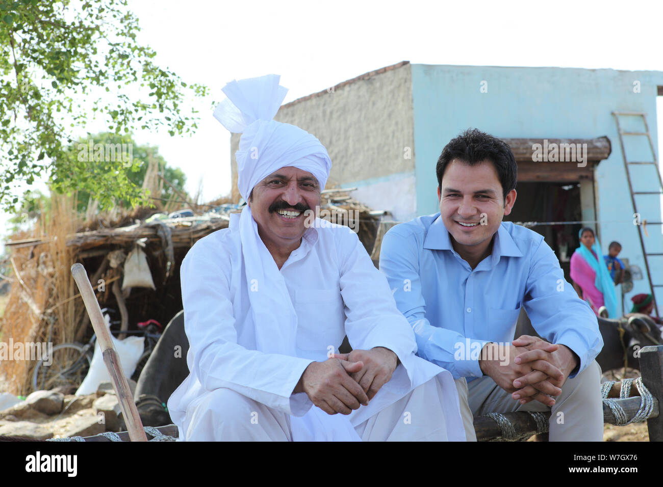 Rural man with his son sitting on cot Stock Photo - Alamy