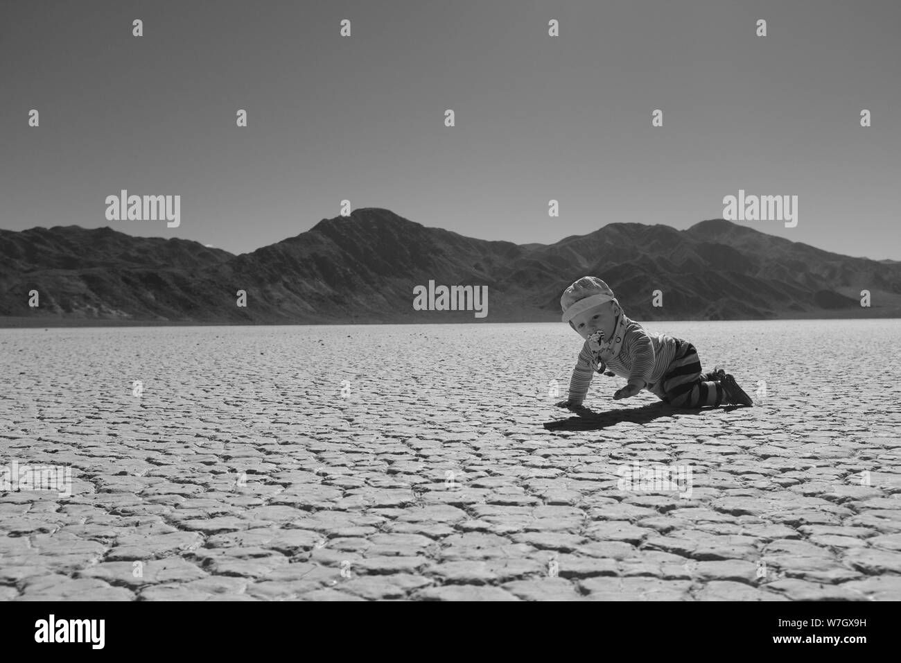 Baby alone on a dry lakebed Stock Photo - Alamy