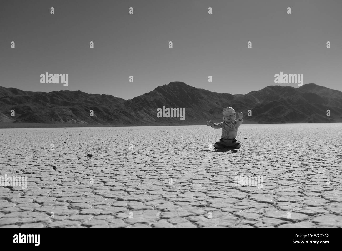 Baby alone on a dry lakebed Stock Photo - Alamy