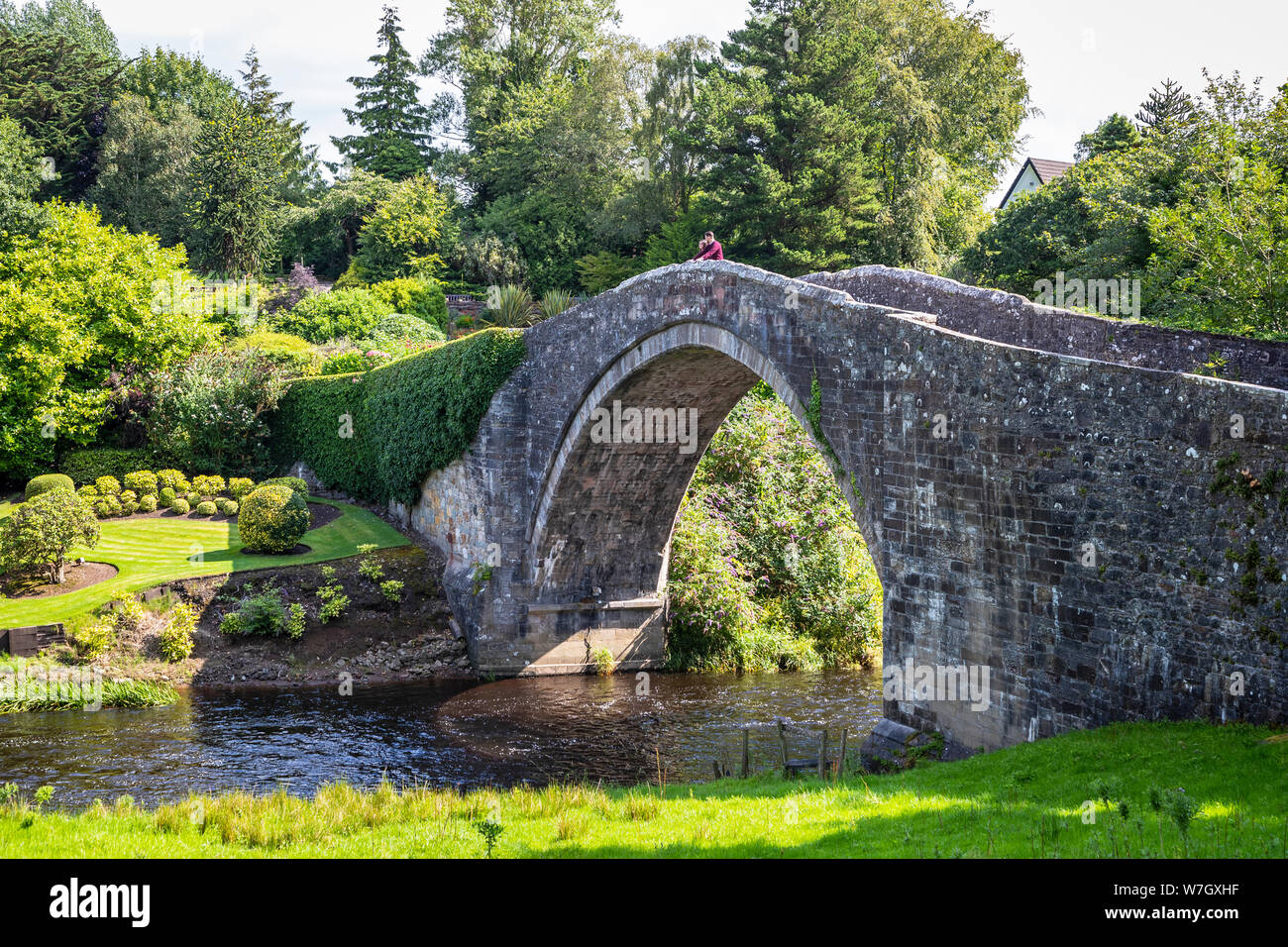 Tourists standing on the Old Brig o'Doon, a 15th-century cobblestone ...