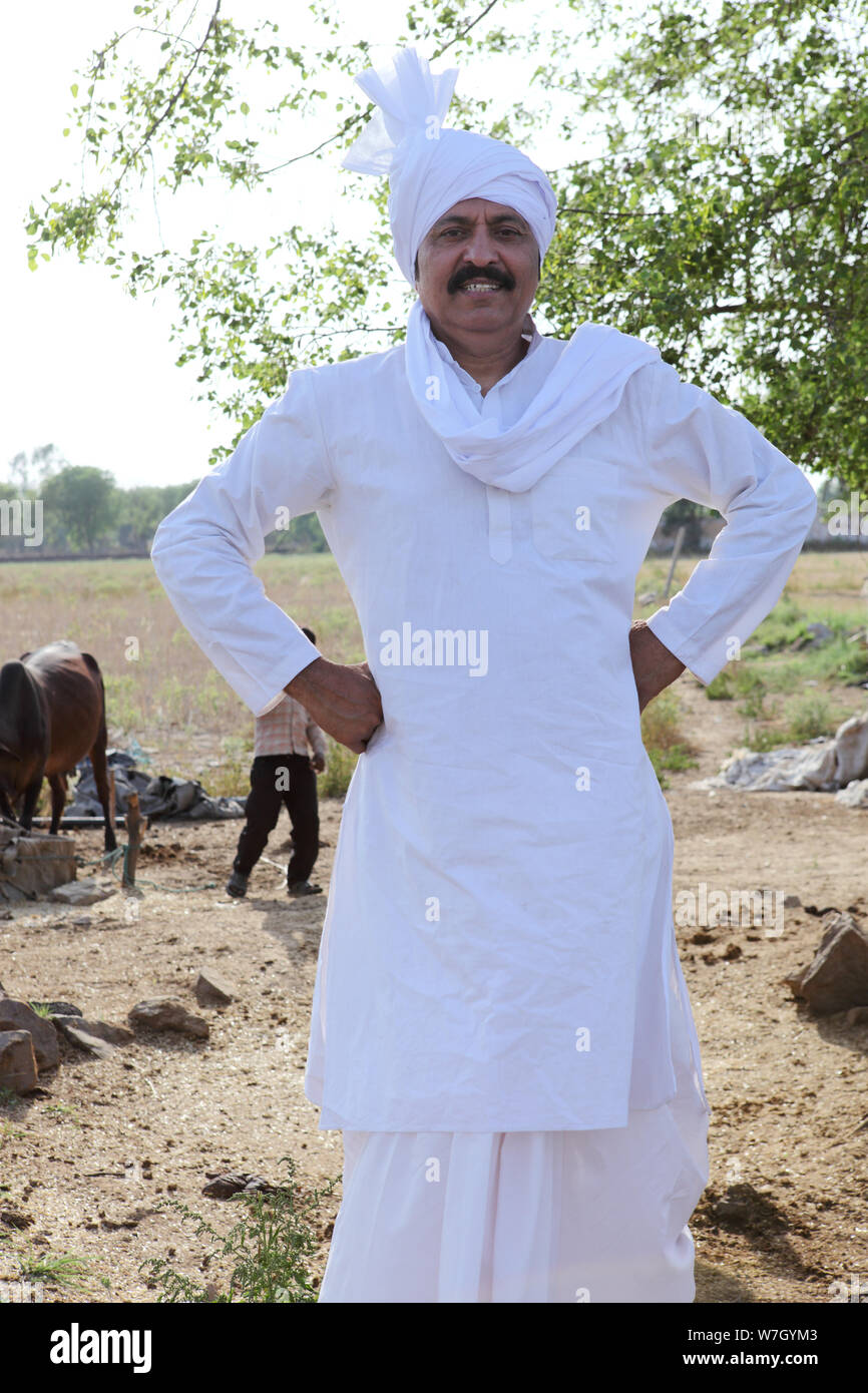 Rural Man standing with his arms akimbo Stock Photo - Alamy