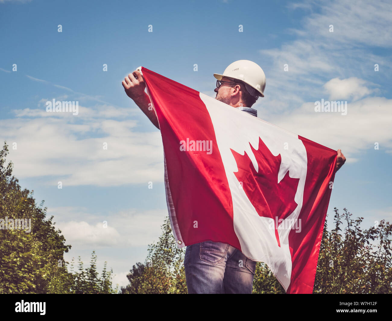Engineer, holding Canadian Flag in the park Stock Photo - Alamy