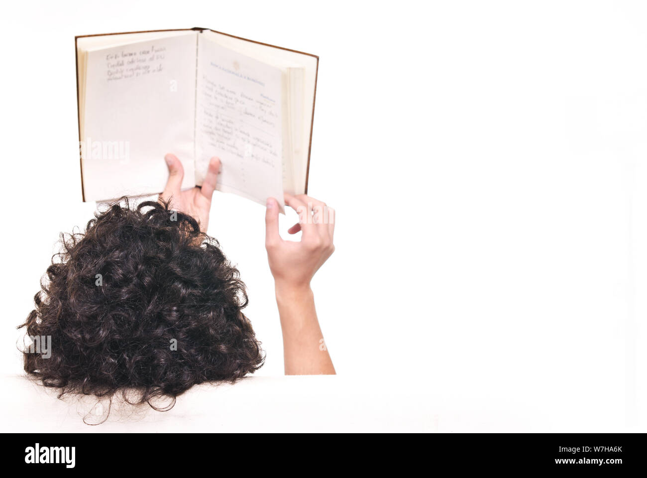 Back view of a person holding book in his hands, studying, reading from ...