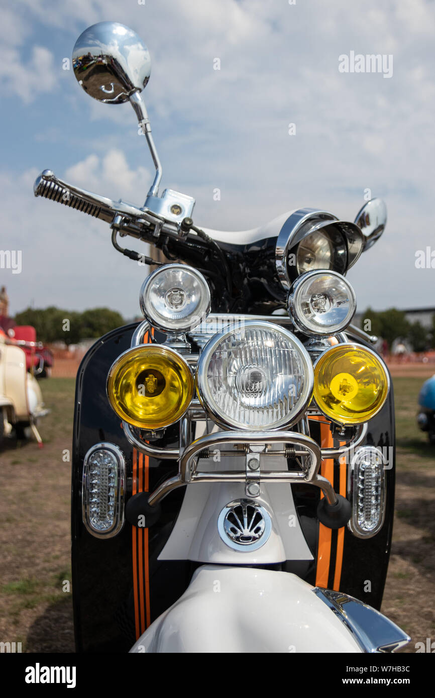 A close up of a vintage moped or scooter with chrome headlights or ...
