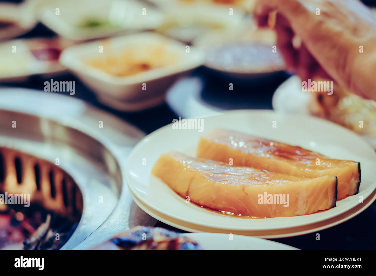 People grilling meat on a smokeless barbecue grill in a restaurant ...