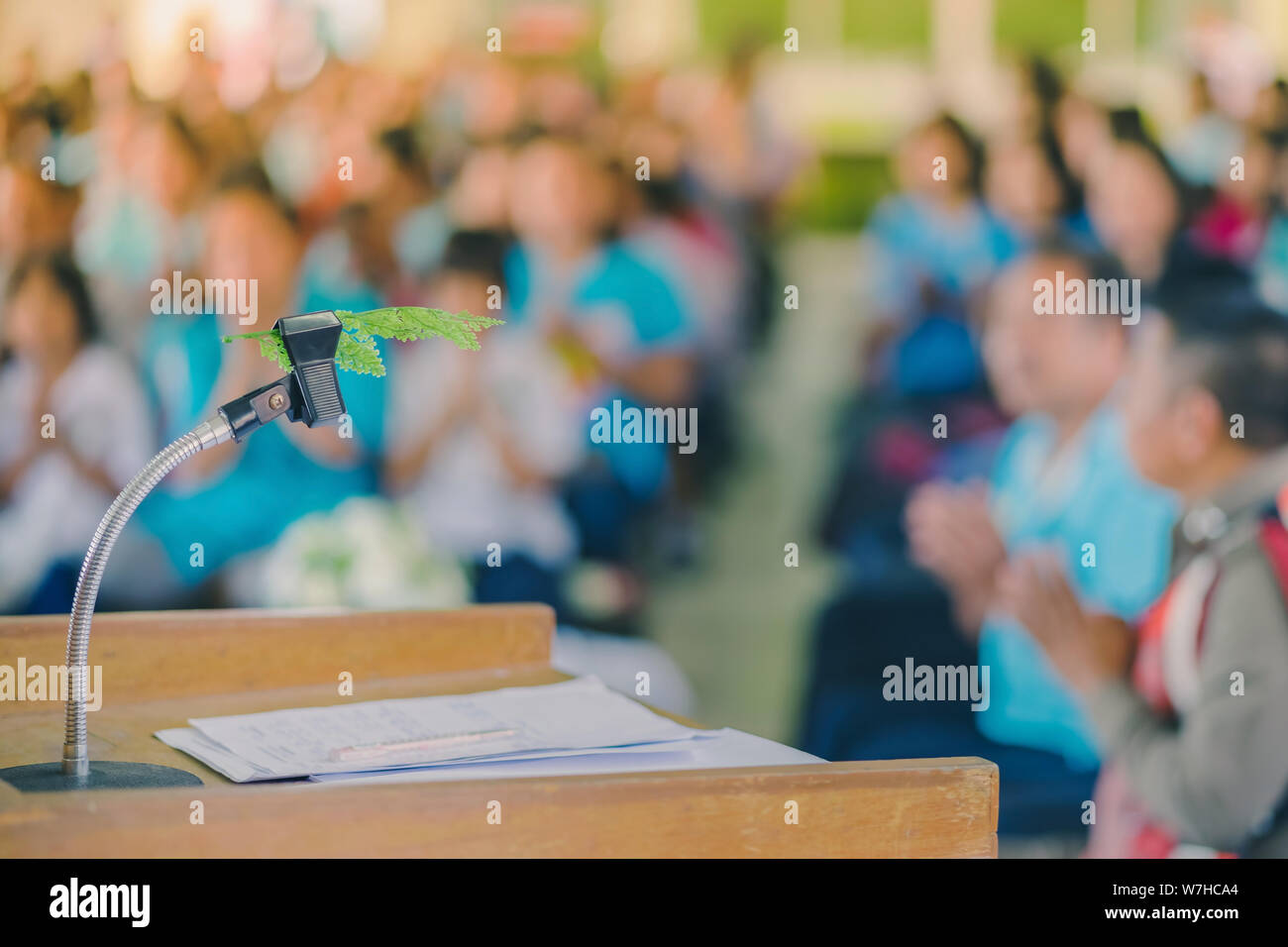 Artificial leaf inserted in the desktop microphone stand on podium in ...