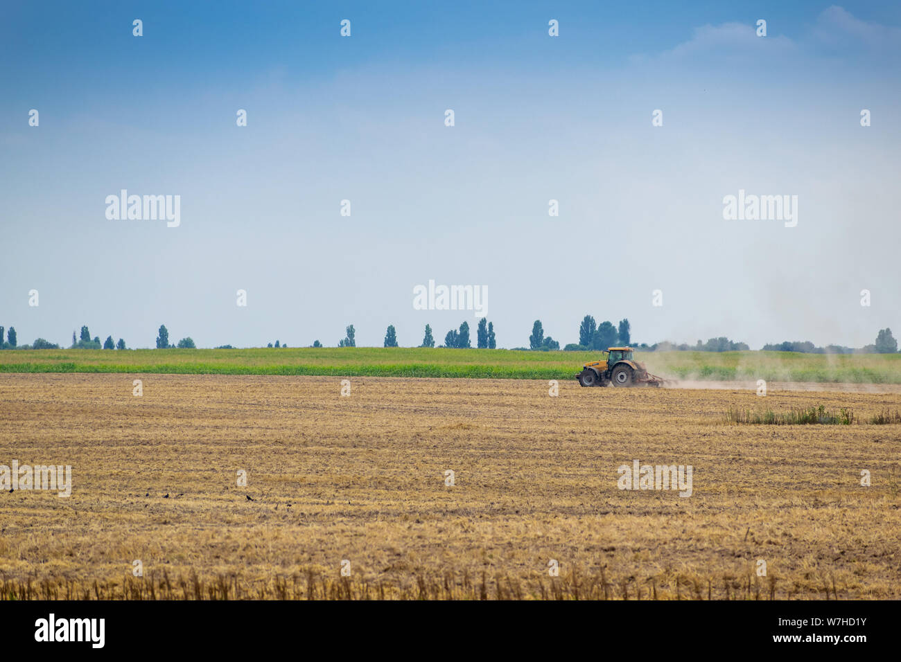 Rural landscape with tractor cultivating the field Stock Photo - Alamy