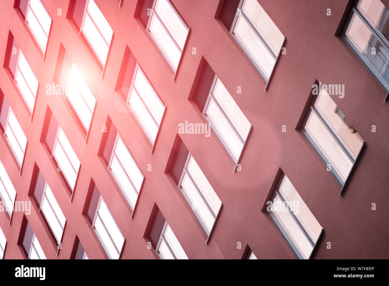 Modern facade of a building with windows reflecting the sun and sky ...