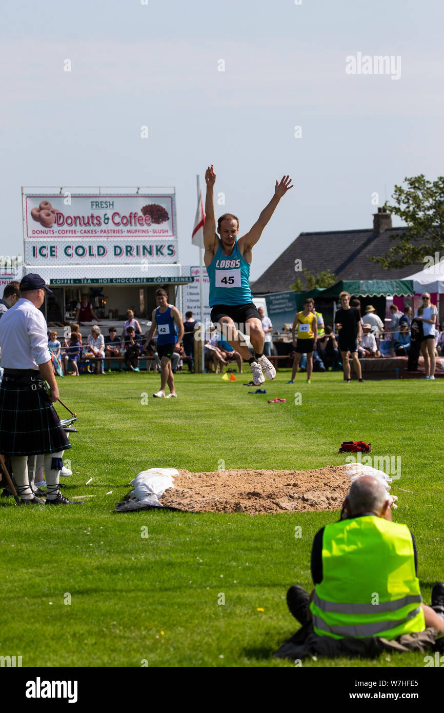 Long jumper in the annual Halkirk Highland Games in mid air at ...
