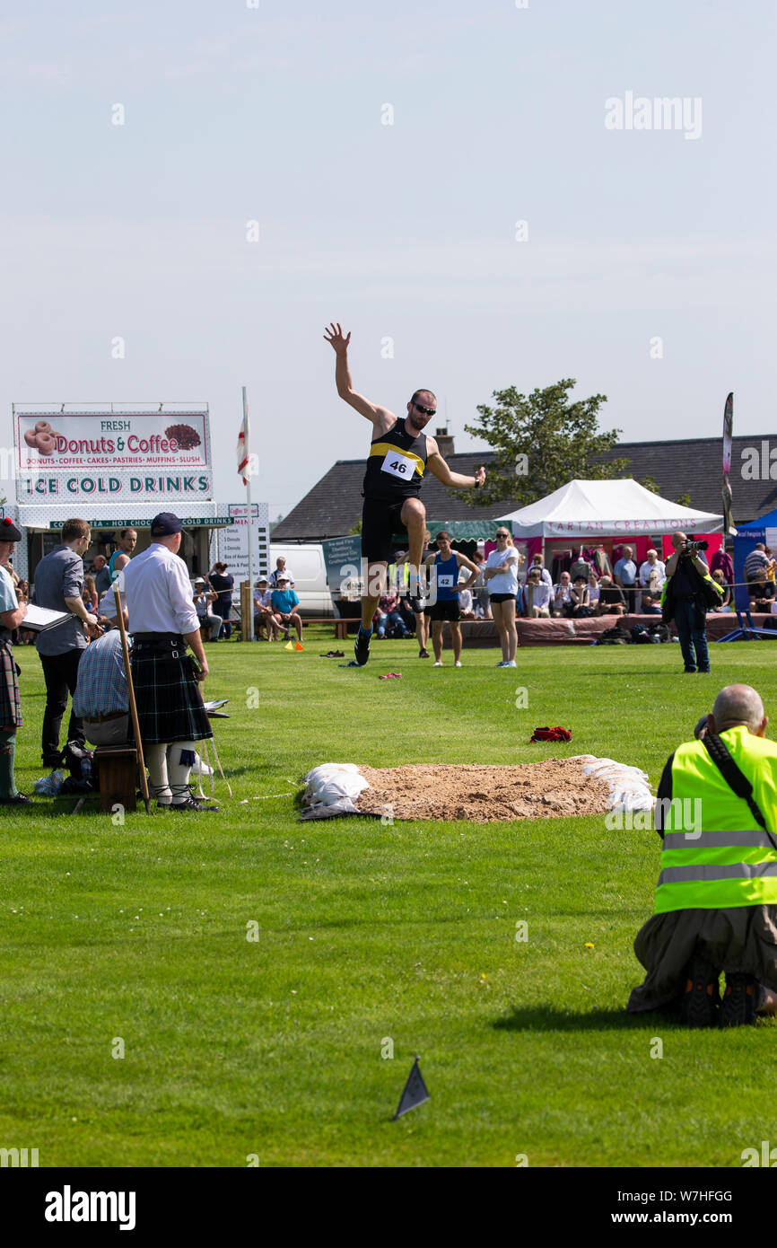 Long jumper in the annual Halkirk Highland Games in mid air at ...