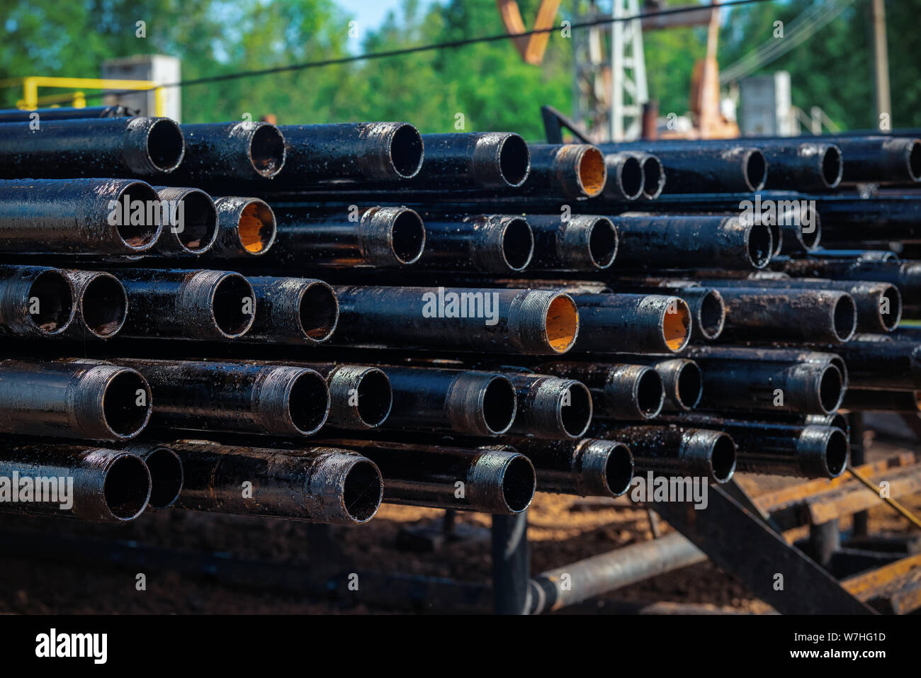 View of drilling pipes casing and tubing stacked at open yard of oil ...