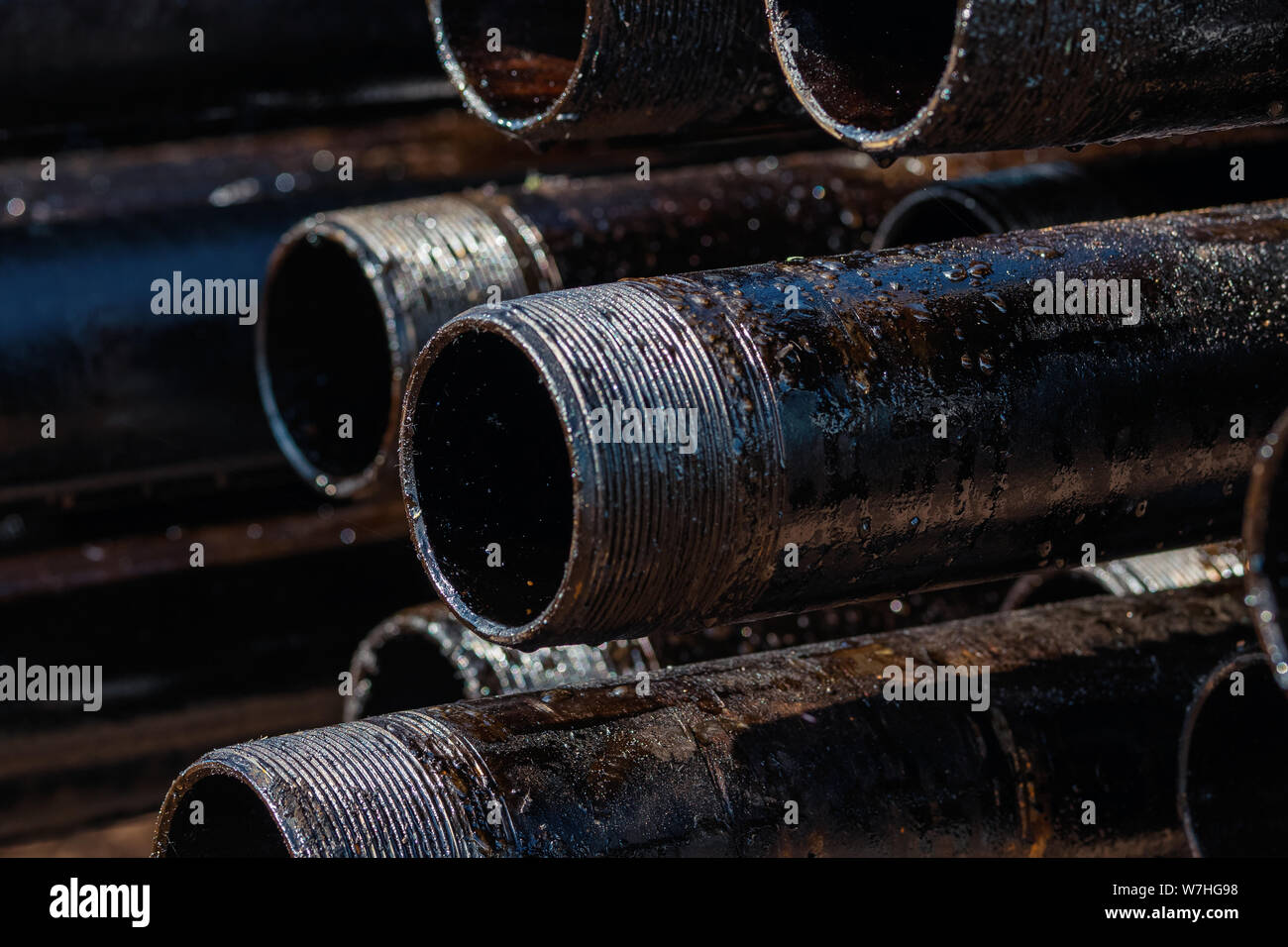View of drilling pipes casing and tubing stacked at open yard of oil ...
